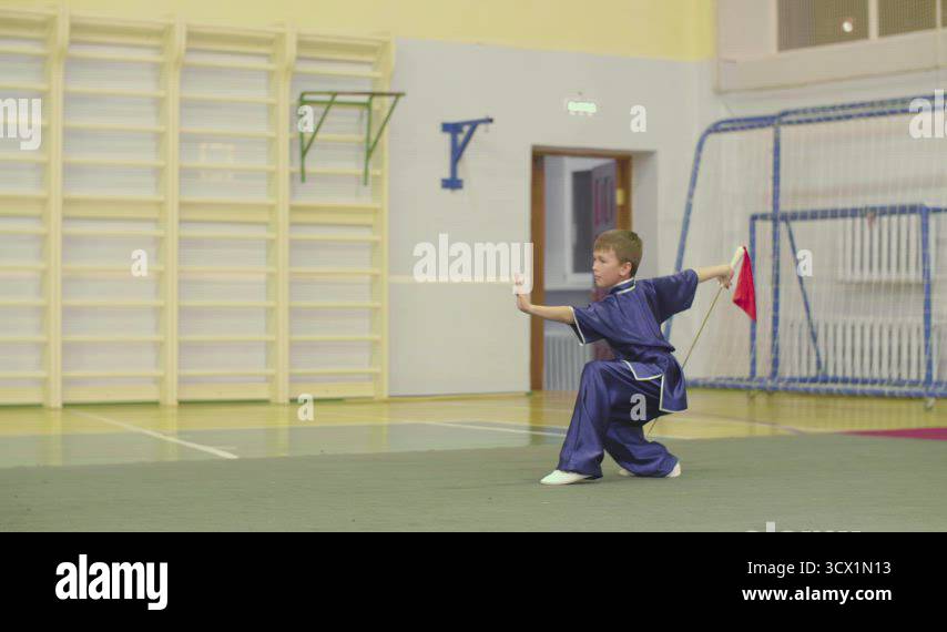 Young boy practicing exercises changquan with sword at martial arts ...