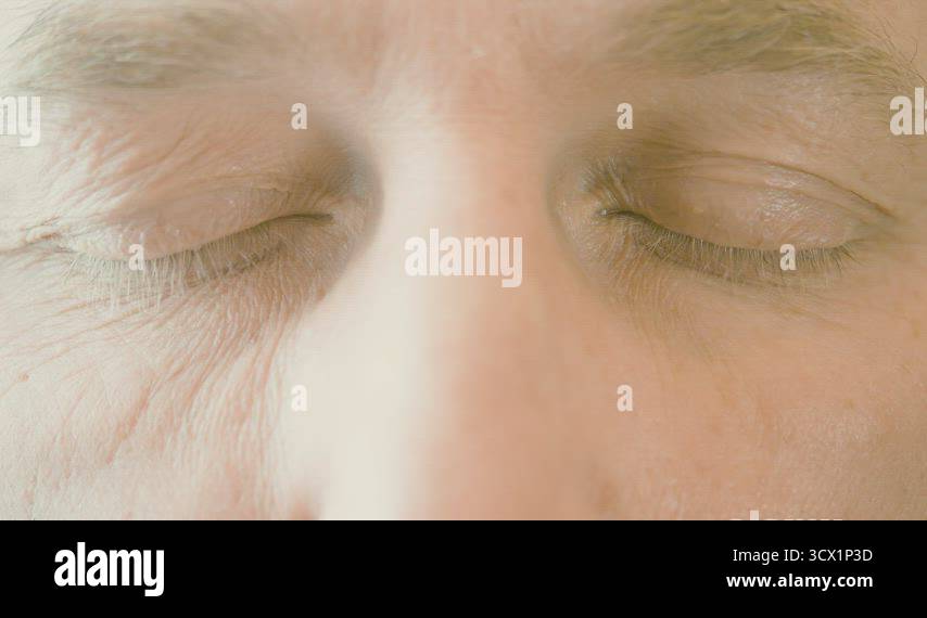 Face and eyes of elderly man winking and looking to camera. Close up ...