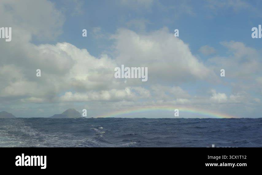 View of rainbow against blue sky with clouds in Indian Ocean, Mauritius ...