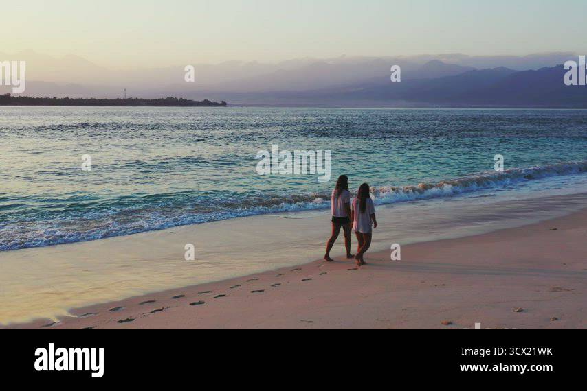 Young smiling girls on holiday in the sun on beach on summer white ...