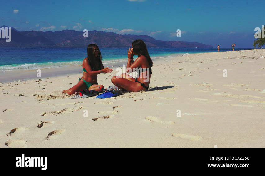Modern smiling girls on holiday in the sun at the beach on paradise ...