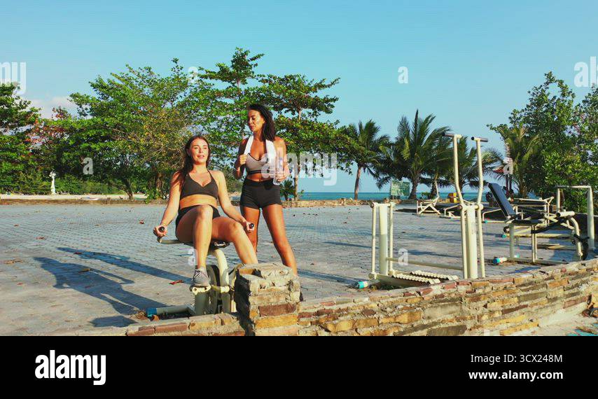 Pretty fun women on holiday in the sun on beach on sunny blue and white ...