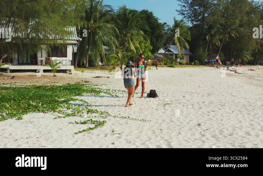 Young smiling girls on holiday in the sun on beach on summer white ...