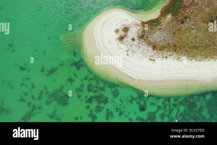 Wide angle overhead island view of a sandy white paradise beach and ...