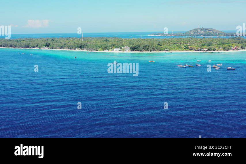 Wide fly over tourism shot of a sandy white paradise beach and blue sea ...