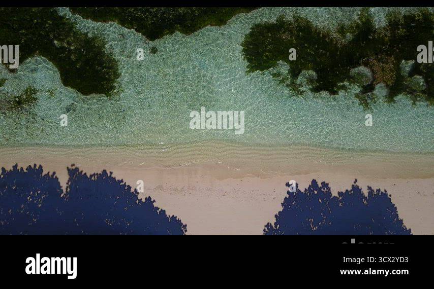 Wide overhead island view of a sandy white paradise beach and blue sea ...