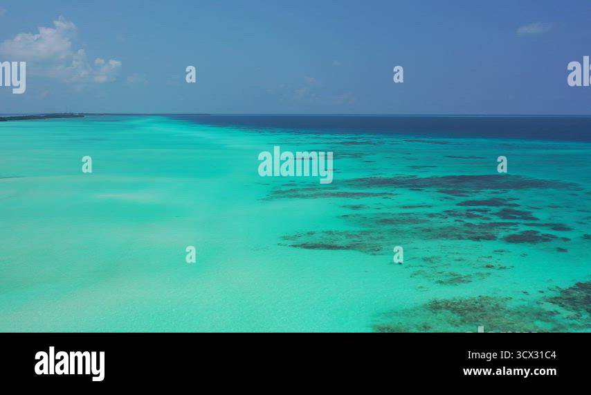 Wide fly over tourism shot of a sandy white paradise beach and blue sea ...