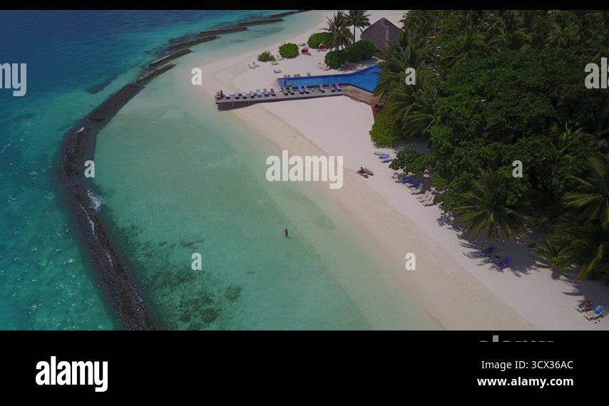 Wide overhead island view of a white sandy paradise beach and aqua blue ...