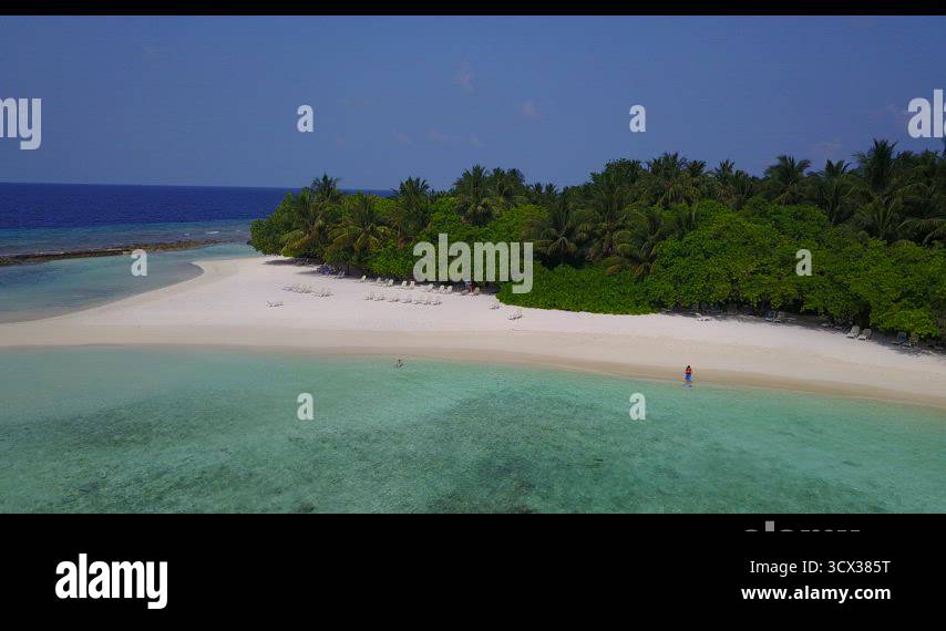 Wide overhead island view of a paradise sunny white sand beach and ...