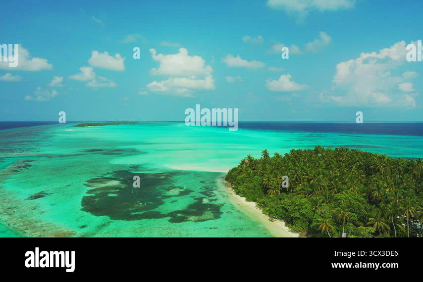 Wide angle fly over island view of a white sand paradise beach and blue ...