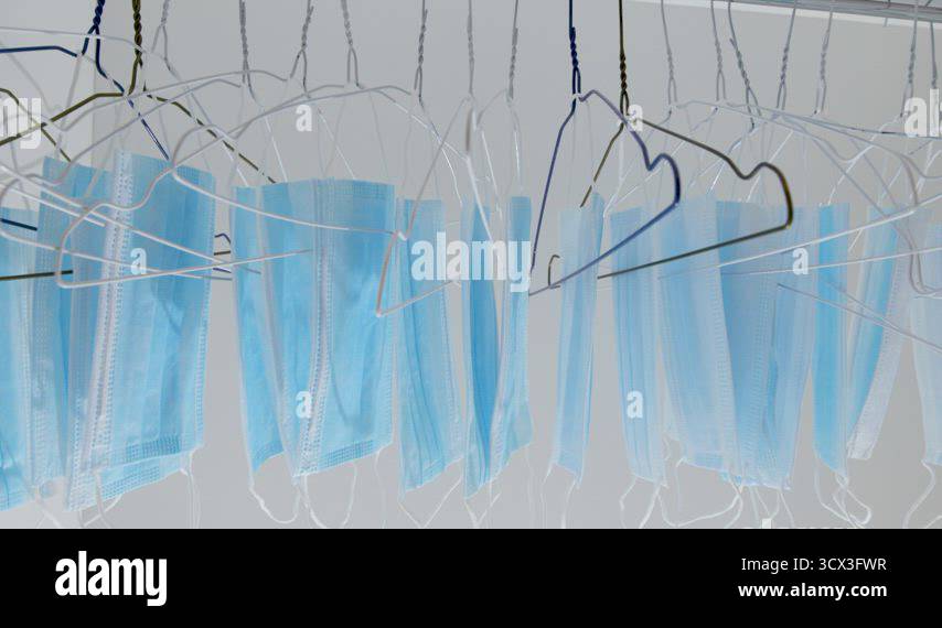 Man opening a wardrobe closet full of disposable masks hanging instead ...