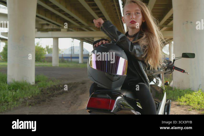 Biker girl with moto helmet sitting on motorcycle under car bridge in ...