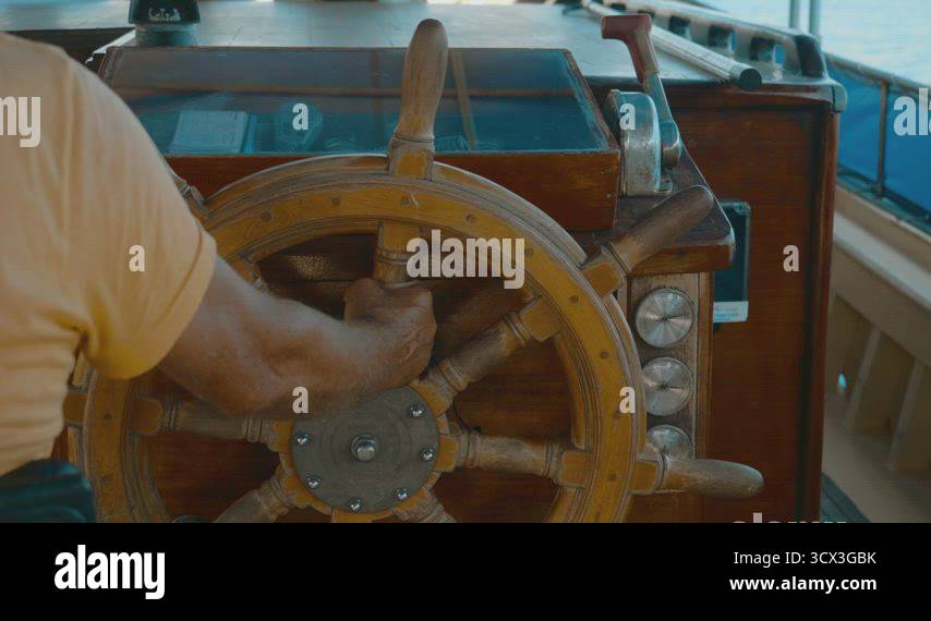 Captain ship holding steering wheel on sailing vessel in sea. Male ...