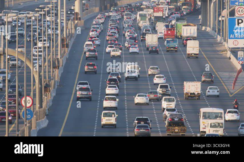 Big traffic pile of cars on a huge highway with many lanes. Traffic slowly coming to a full stop ...