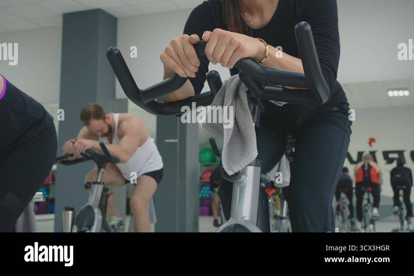 Fitness woman training on bike machine on cycling class in gym club ...