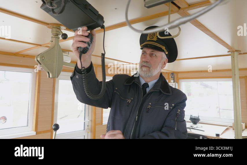 Bearded captain of ship setting radio on captain bridge. Navigation ...
