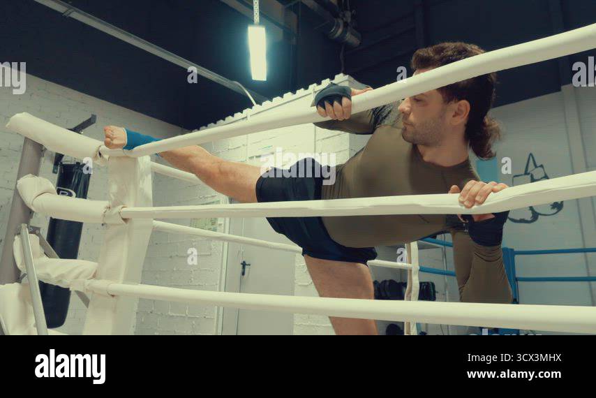 Boxer man doing stretching legs before boxing training on box ring in ...
