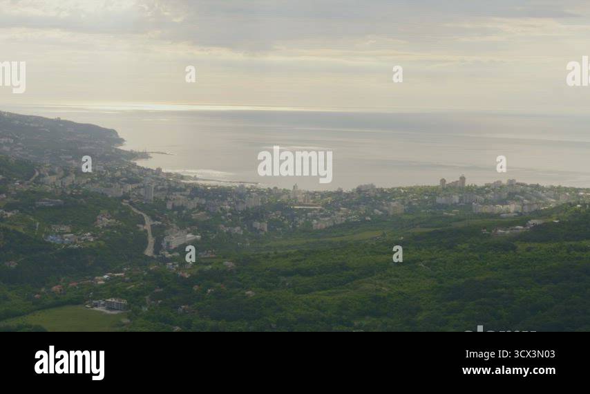Panoramic view modern city in valley on sea shore from mountain peak ...