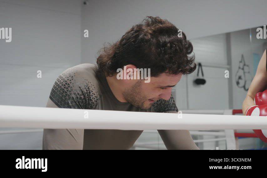 Tired boxer man resting after fighting on ring rope. Exhausted boxer ...