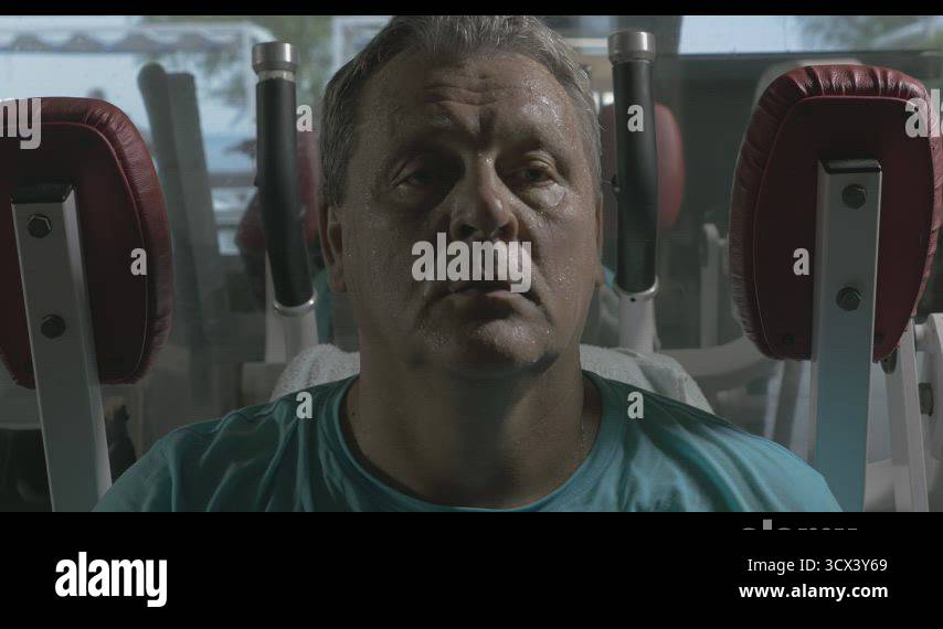 Grown man in blue shirt in the gym performing exercises on the upper ...