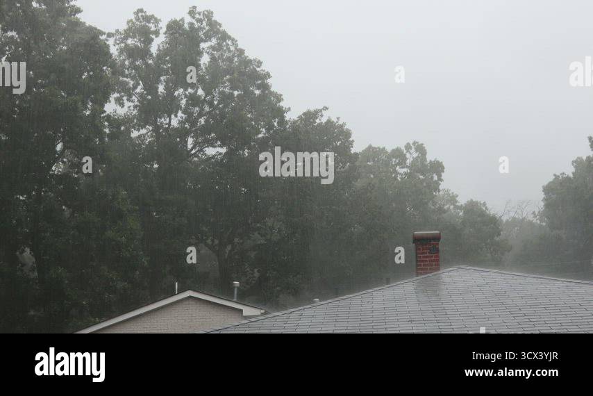Downpour in the summer storm heavy rain with house shingle roof of ...