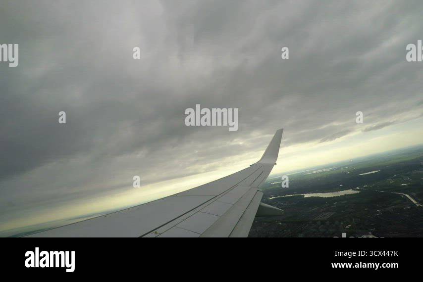 Airplane wing window view, after take off from airport, flying above ...