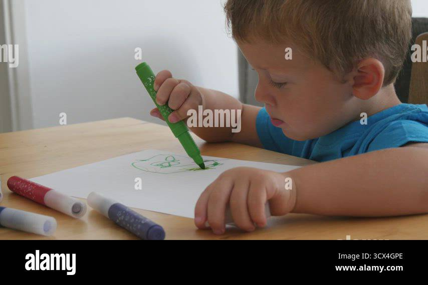 small cute boy drawings colored pencils on a sheet of paper Stock Video ...