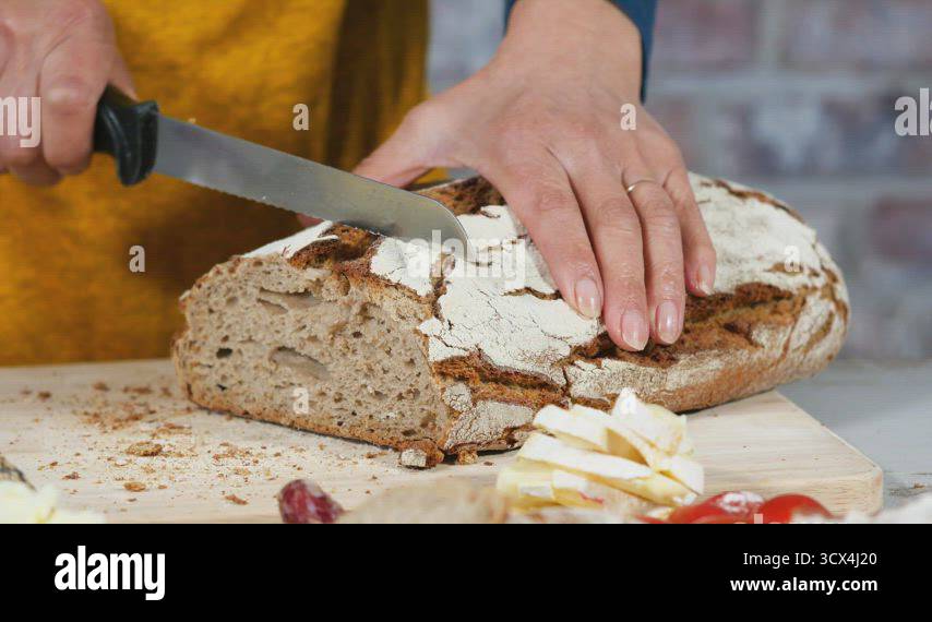 woman hands cuts a traditional bread slice Stock Video Footage - Alamy