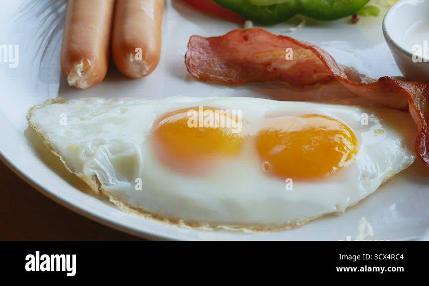 A person eating breakfast. American style breakfast with fried eggs ...