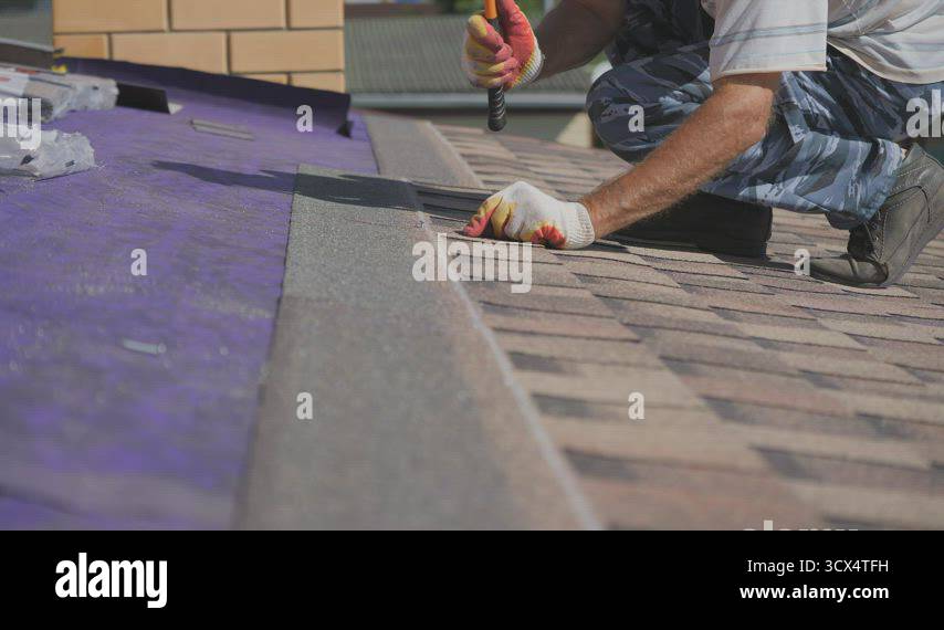 Roofing work. Laying a soft roof on the roof of a private house Stock ...