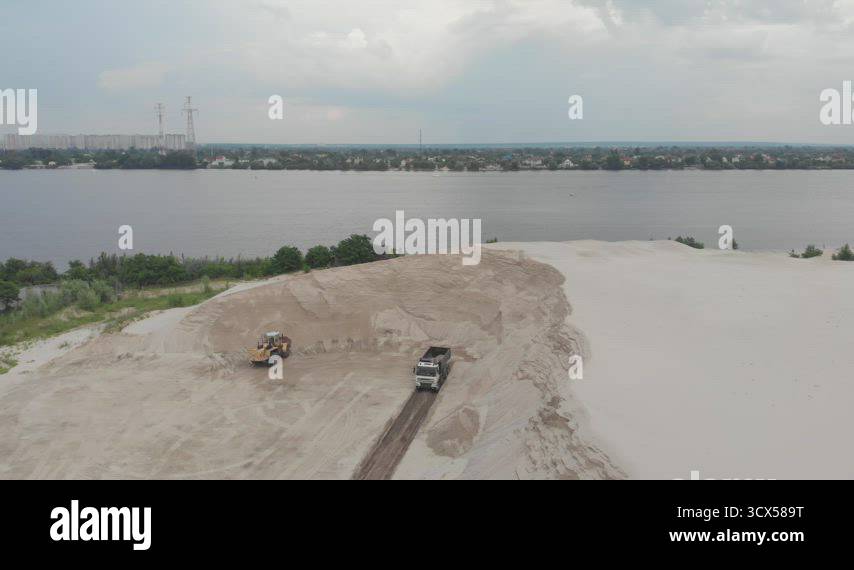 Aerial of excavator loading sand into large dump truck. Huge sand ...
