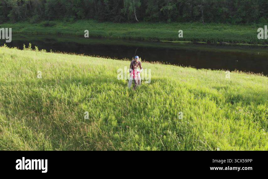 Father and daughter having fun at riverfront in summer thow girl in the ...