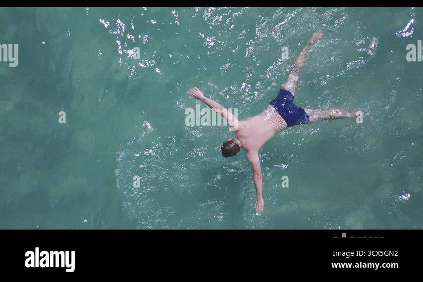 Male body floating in water. Aerial drone shot of drowned guy in the ...