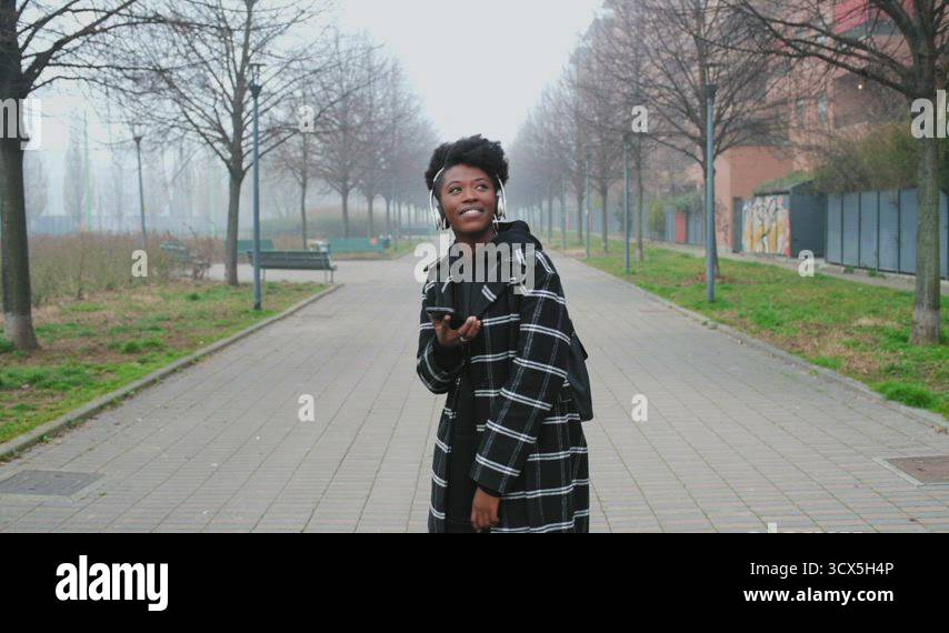 MS Woman listening to music on sidewalk, Milan, Italy Stock Video ...