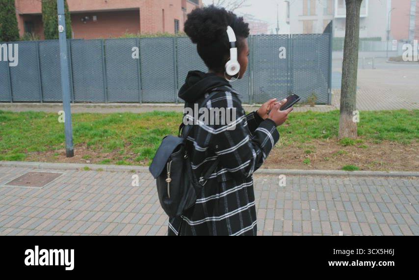 MS Woman listening to music on sidewalk, Milan, Italy Stock Video ...