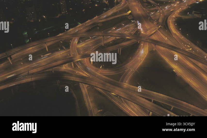 Illuminated Complex Road Junction and Cars Traffic at Night. Drone is ...
