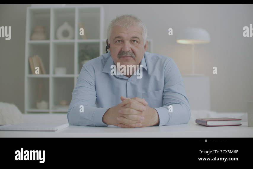 gray haired man is looking at camera and nodding by head, webcam ...