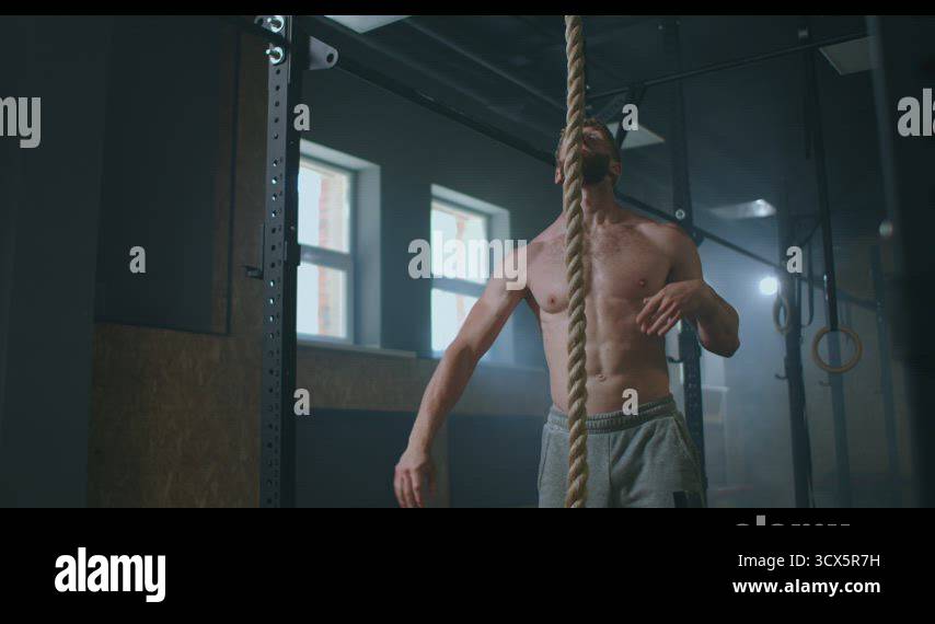 strong men during training climb the rope to the top. training for ...