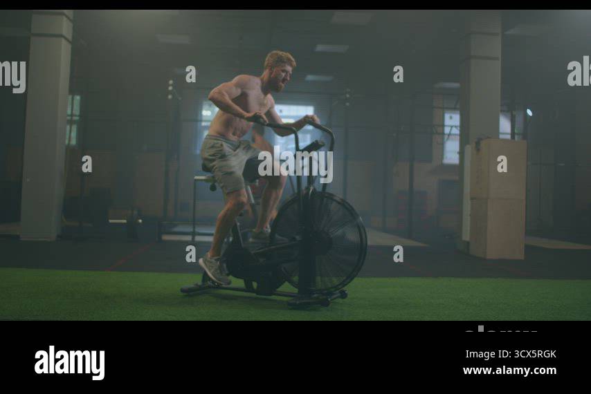 Fitness man on bicycle doing spinning at gym. Fit young male working ...