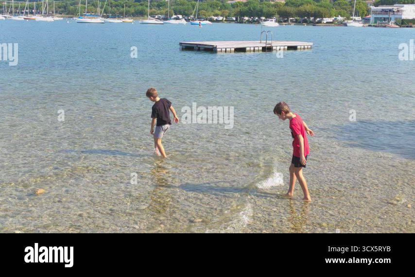 Children plays on Garda Lake Stock Video Footage - Alamy
