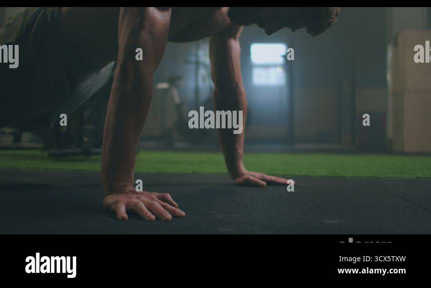 a strong man performs push-UPS from the floor with all his strength. a ...