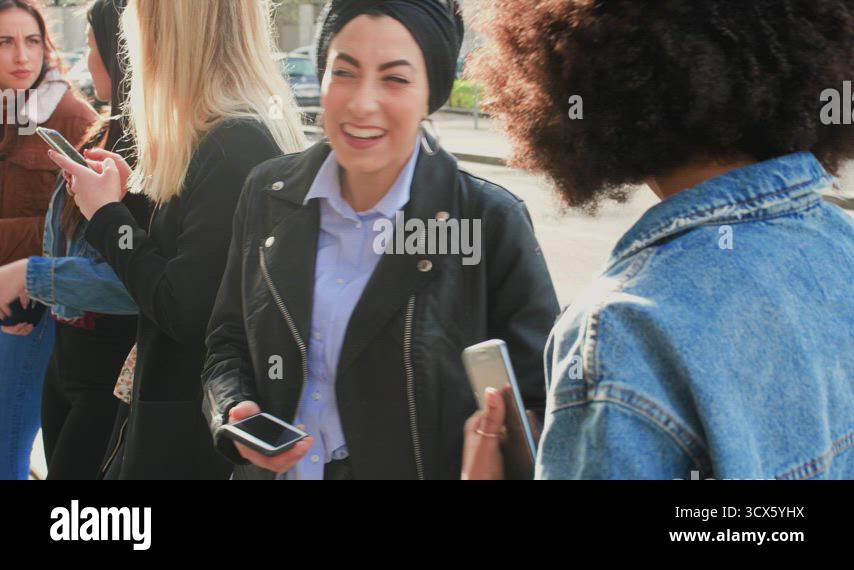 A group of girls, young women, female friends in a gang out on the ...