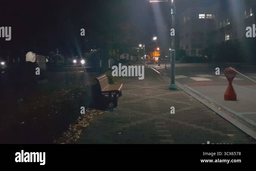 Street walk view of public park at night under dim street lights Stock ...