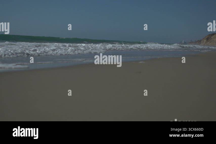 Low angle view and slow motion shot of sea shore with waves and sea ...