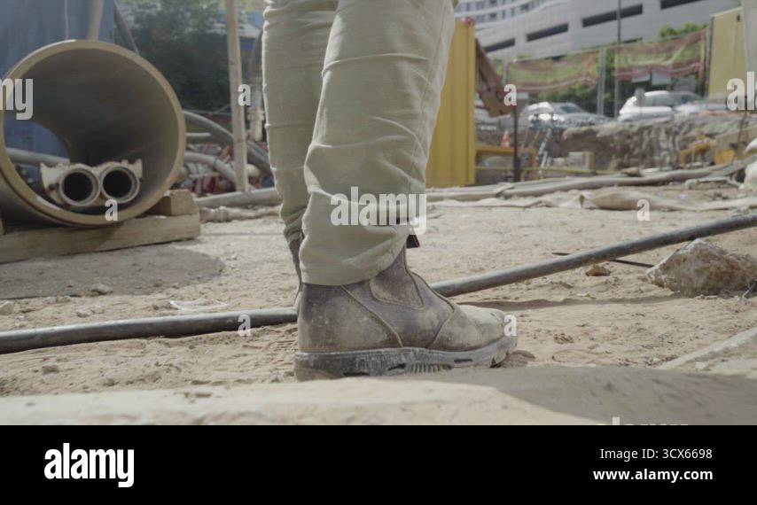 Man walking through working industrial site. Follow shot to a male ...