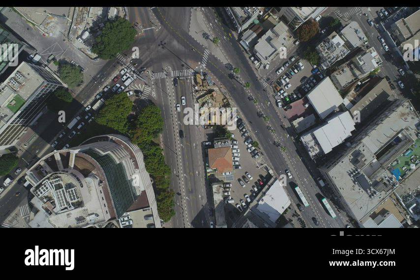 Top down Aerial shot over intersection traffic at day time with cars ...