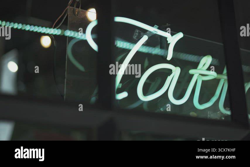 Blue Tattoo Light Sign on a Window From a Barbershop and Tattoo Studio ...