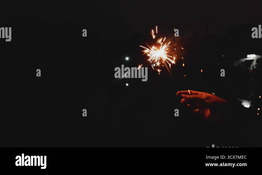 Slow video clip of a yellow scab splashing from fireworks in hand and ...