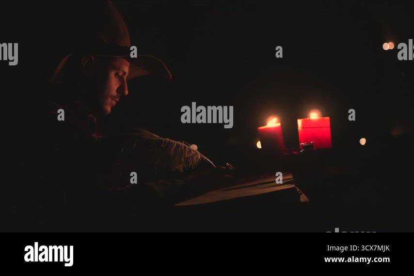 Wizard writing on paper with feather pen and ink. Lit up by candles ...