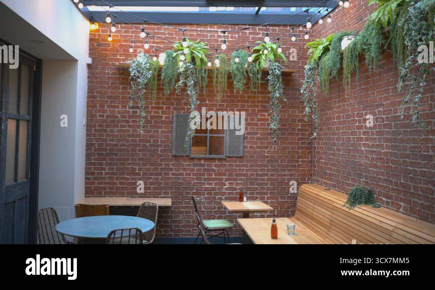 Plants hanging from the brick walls of a vegan restaurant with a glass ...